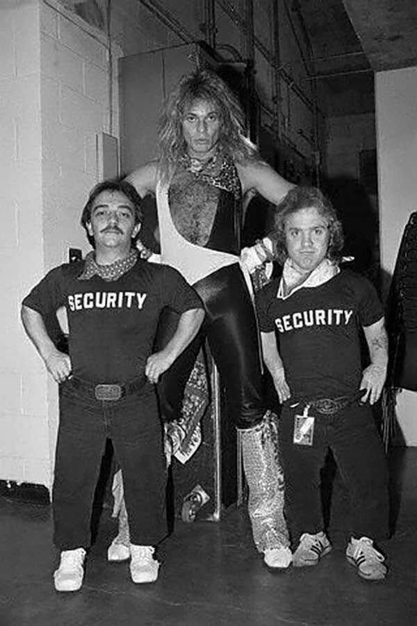 David Lee Roth posing with Van Halen's security, 1982.